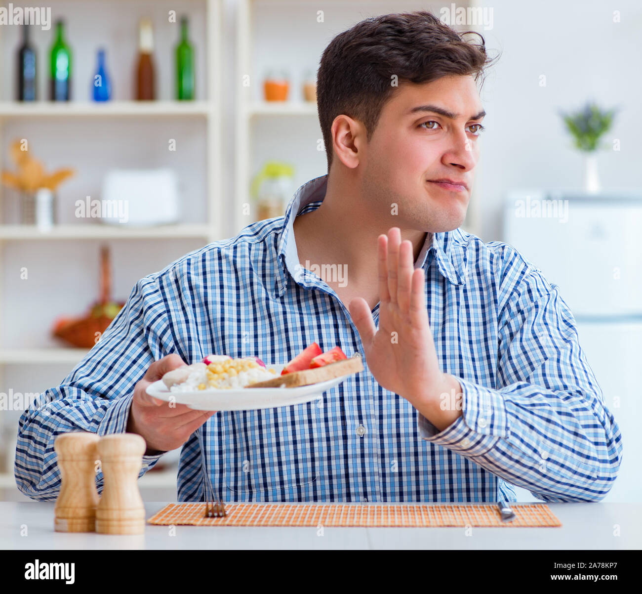 The young husband eating tasteless food at home for lunch Stock Photo ...