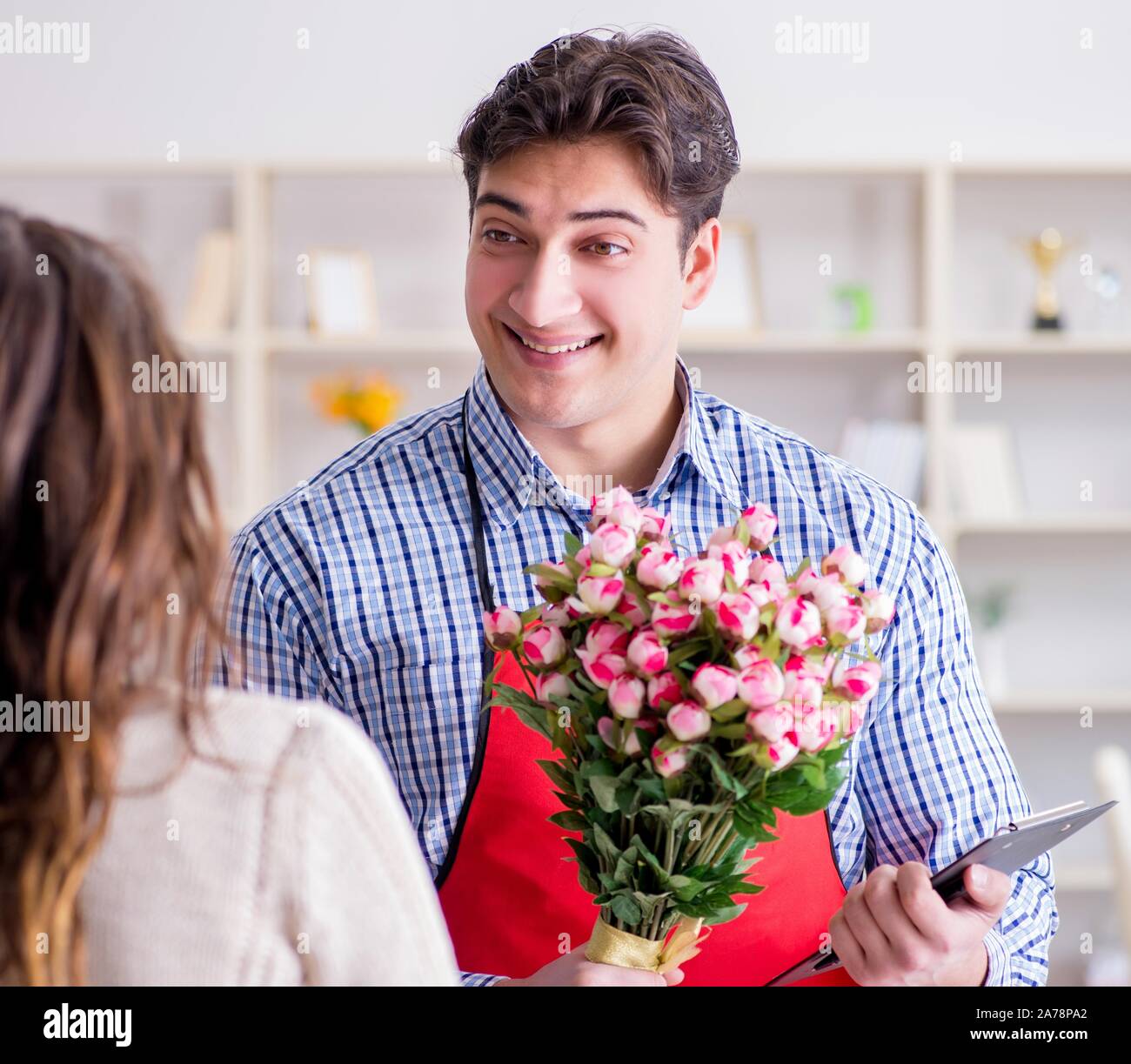 Flower shop assistant selling flowers to female customer Stock Photo ...