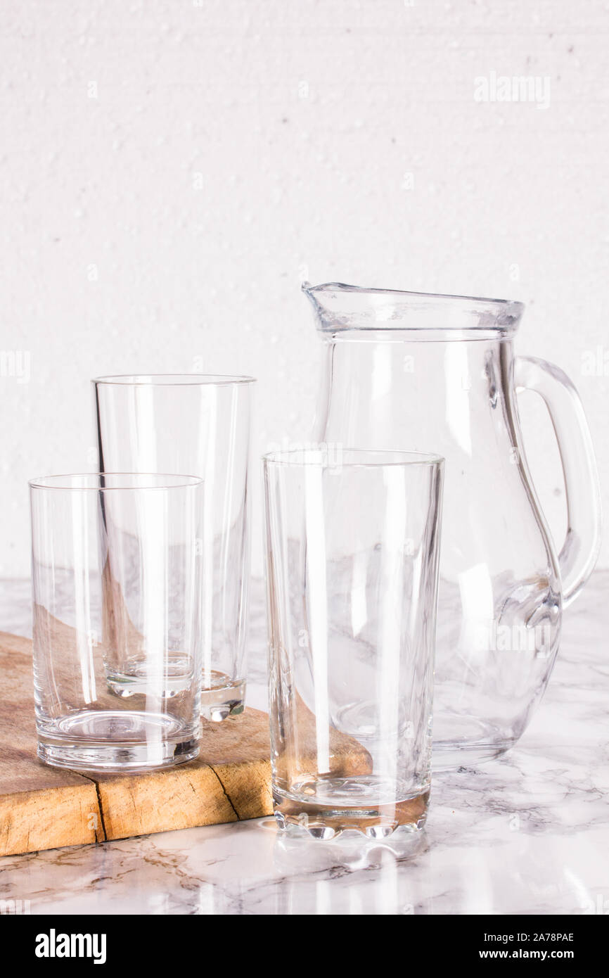 Glass jug and three glasses on the kitchen table Stock Photo - Alamy