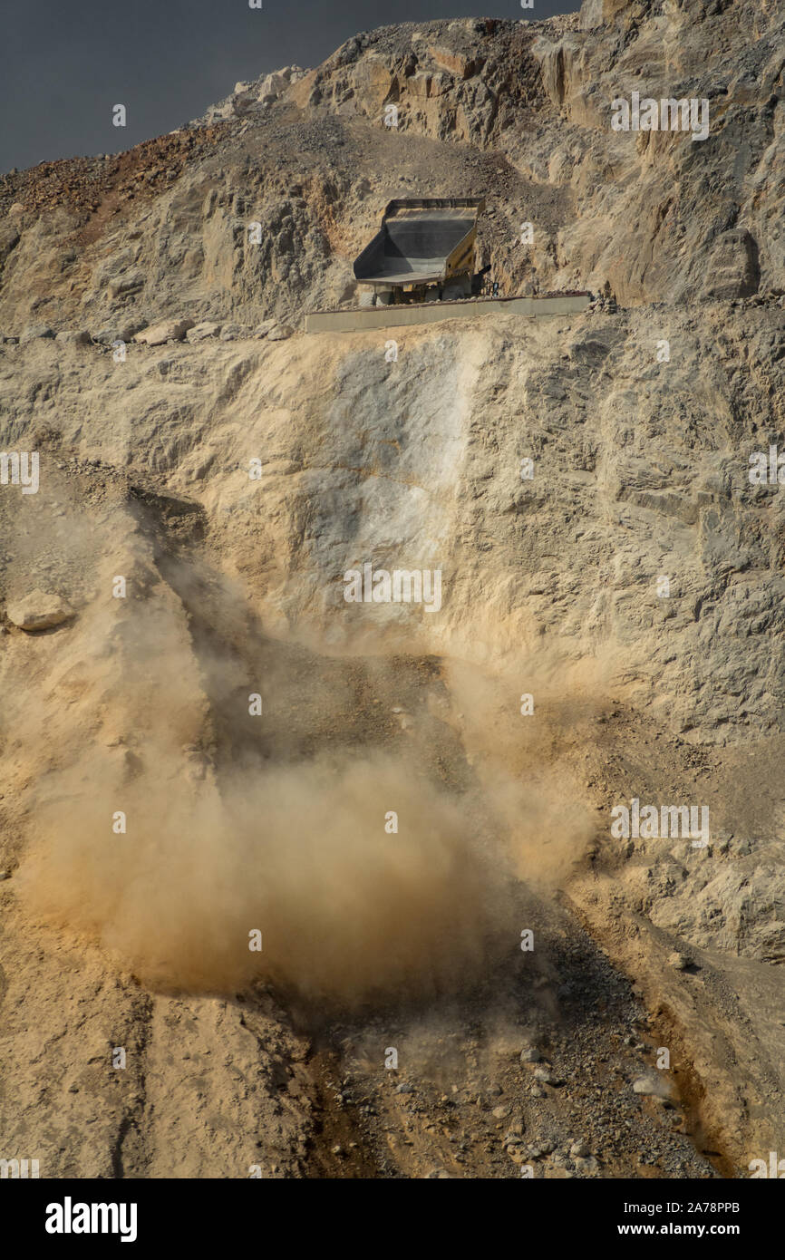 Dumper throwing stone waste to dump, long shot Stock Photo - Alamy