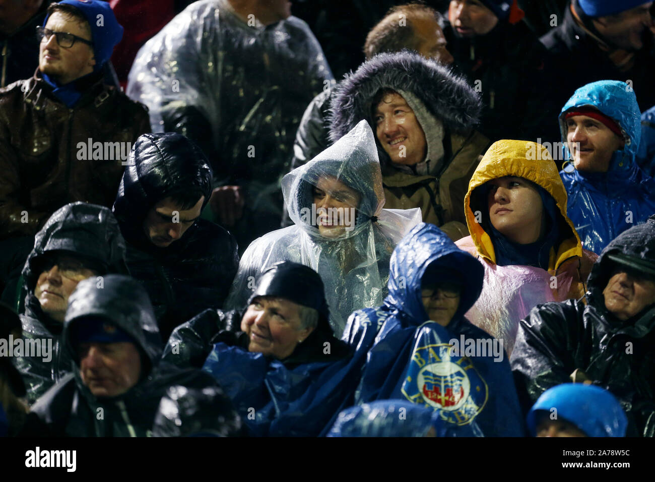 Fans in the stands in the rain Stock Photo - Alamy
