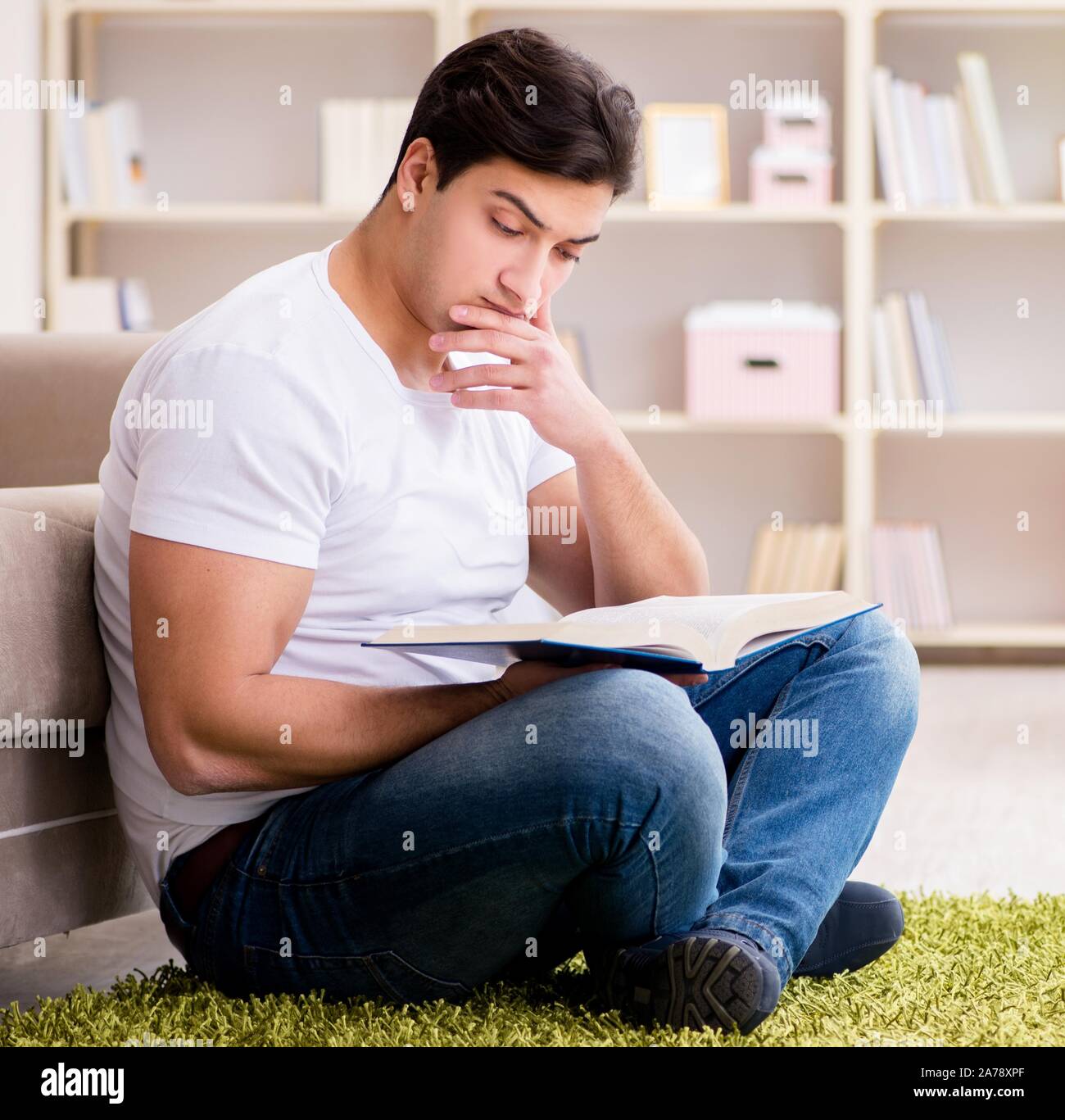 The man reading book at home on floor Stock Photo - Alamy