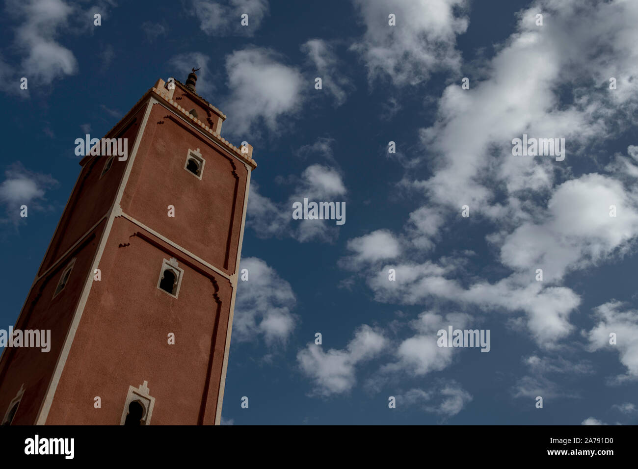 Moroccan square minaret taken from below with beautiful blue sky and ...