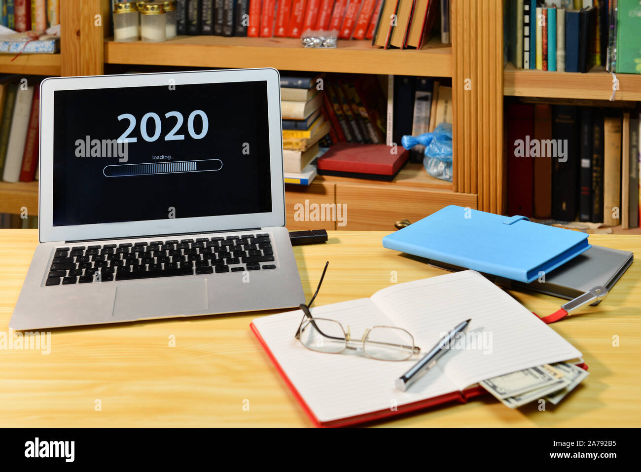 on the table notebook, eyeglases and laptop with text - 2020 loading ...