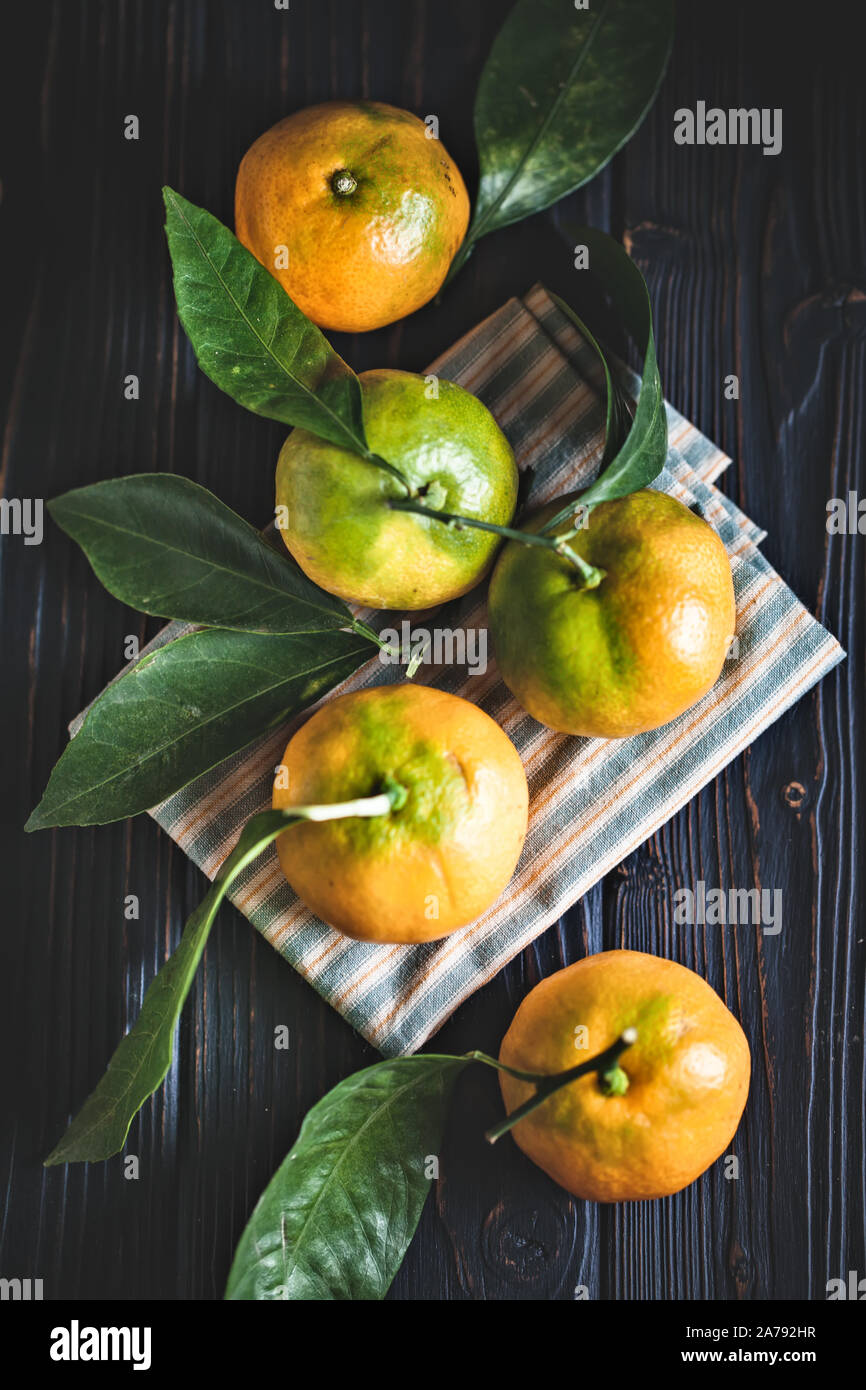 Tangerines with leaves on an old fashioned country table. Selective ...