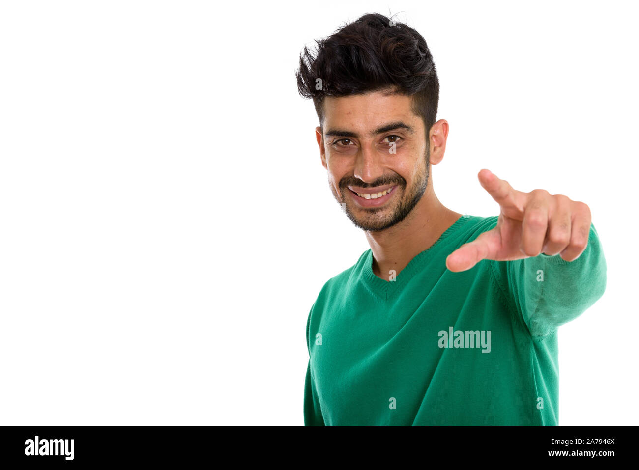 Studio shot of young happy Persian man smiling while pointing at Stock ...