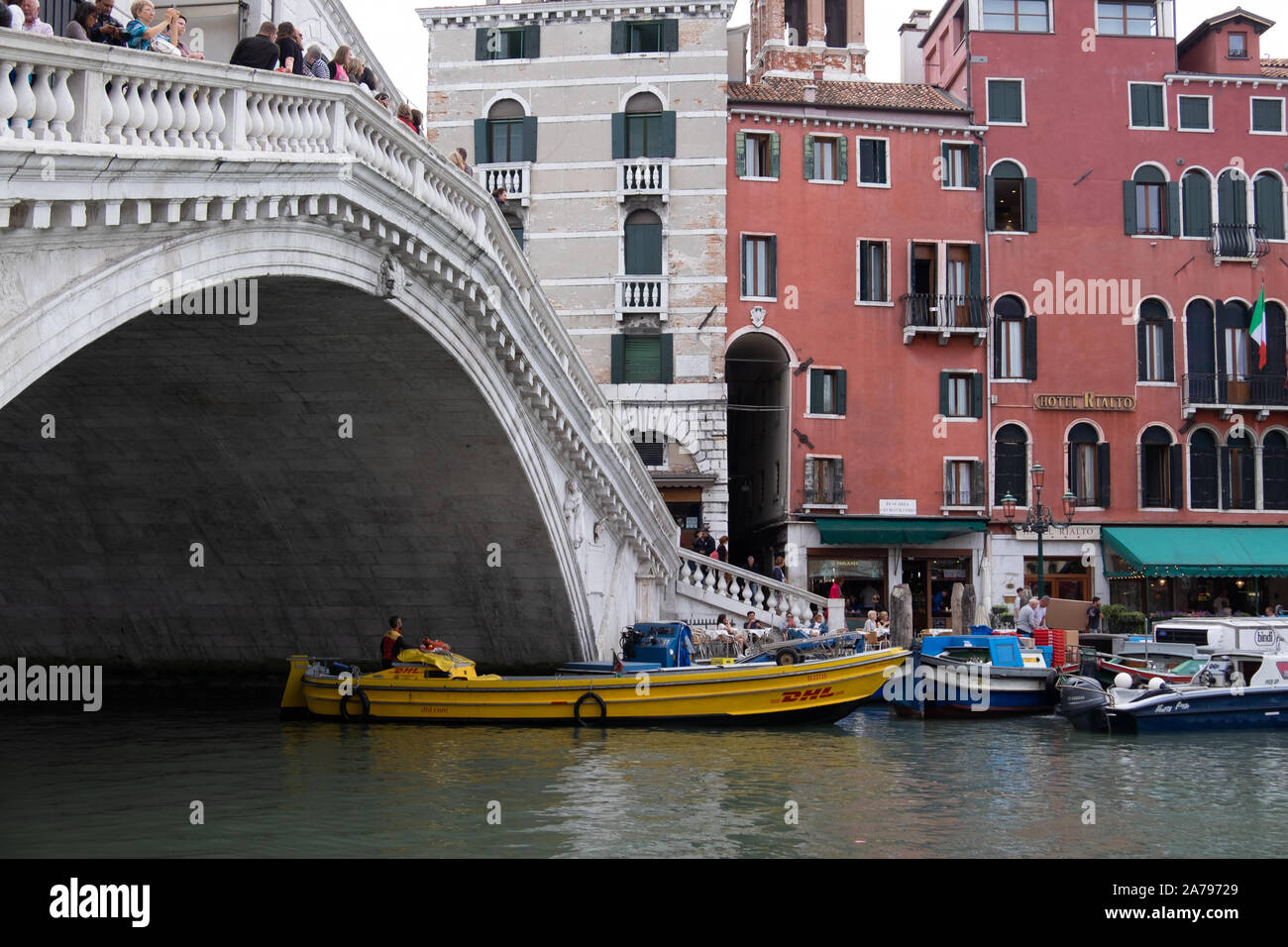 Bright yellow DHL parcel delivery barge under the famous landmark of ...