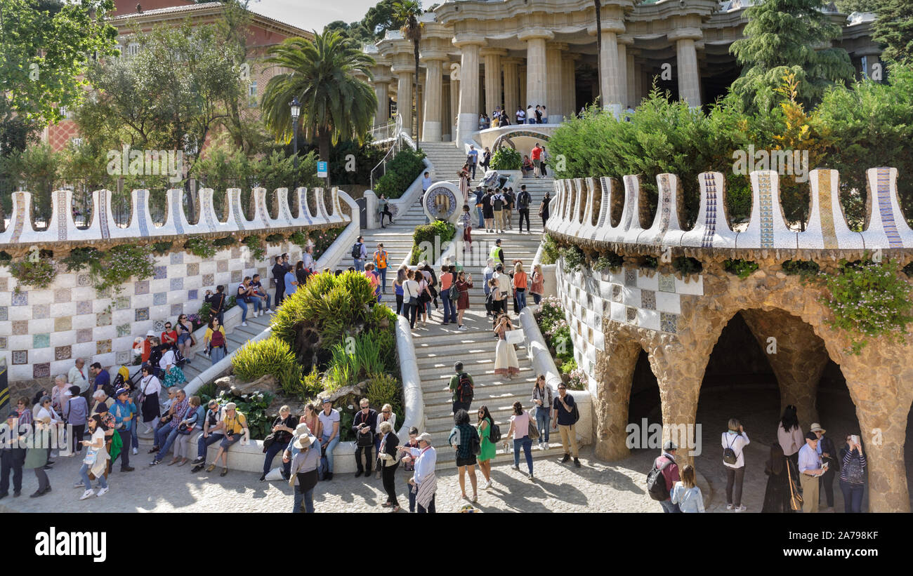 Tourists and people walking around the entrance steps of Park Güell ...