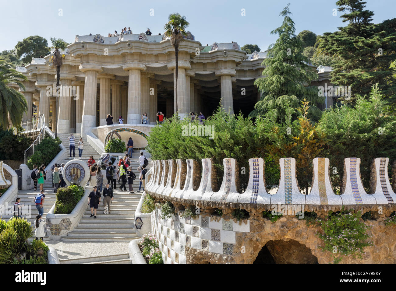 Tourists and people walking around the entrance steps of Park Güell ...