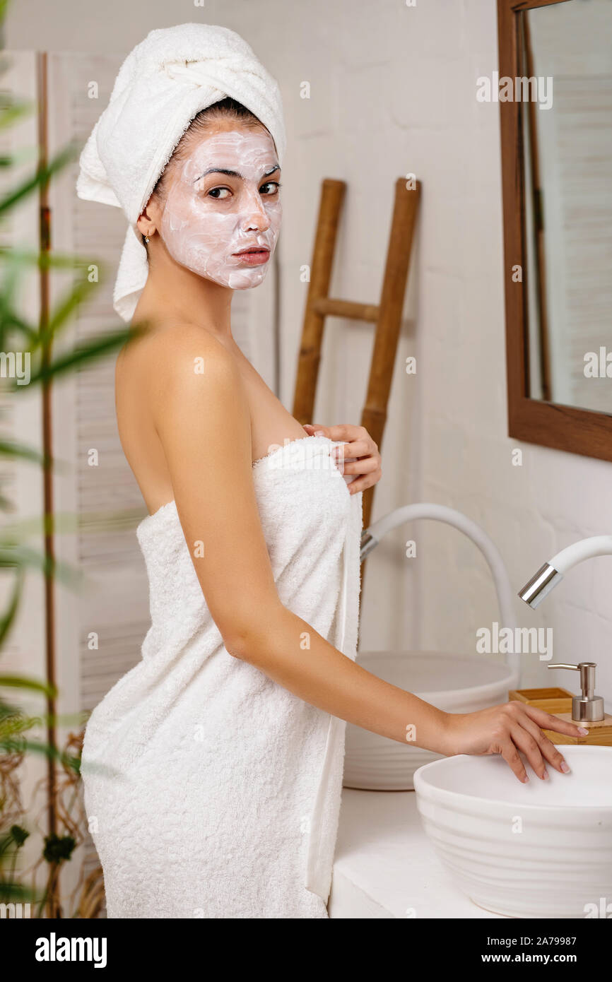 Beautiful Young Woman With Towel Wrapped Around Her Head Is Applying