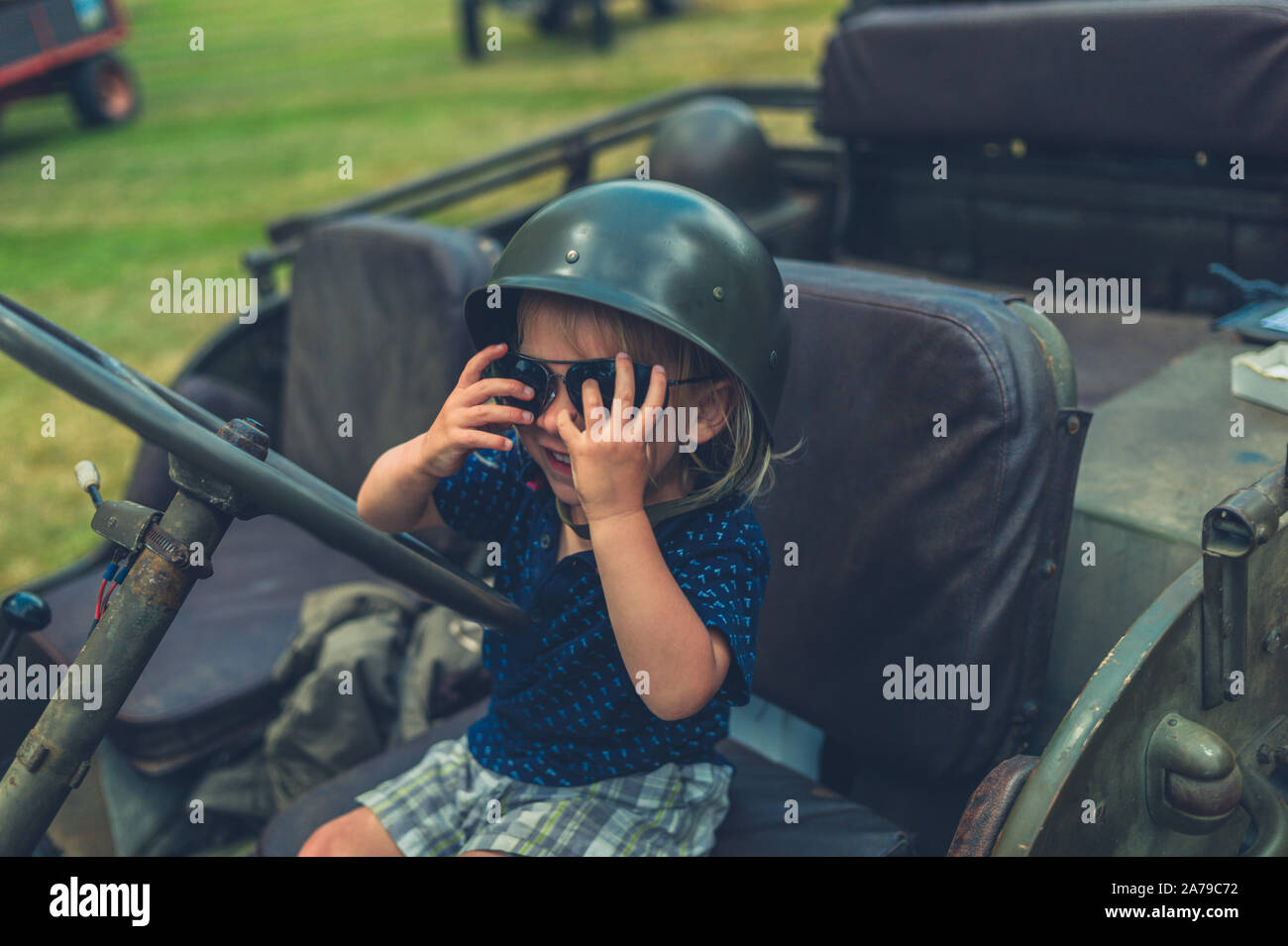 A little toddler is pretending to drive a military vehicle Stock Photo ...