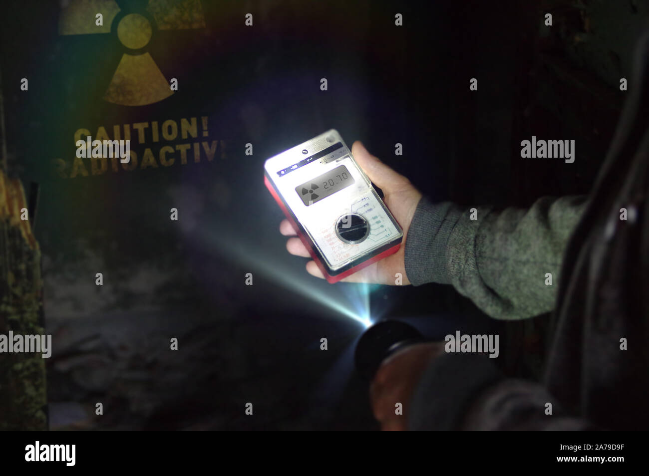 A man with a radiation meter and a flashlight before a warning about ...