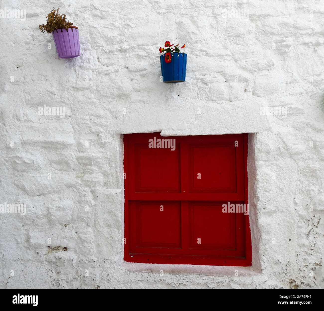 Red window in a white house with vases of flowers on the wall Stock ...