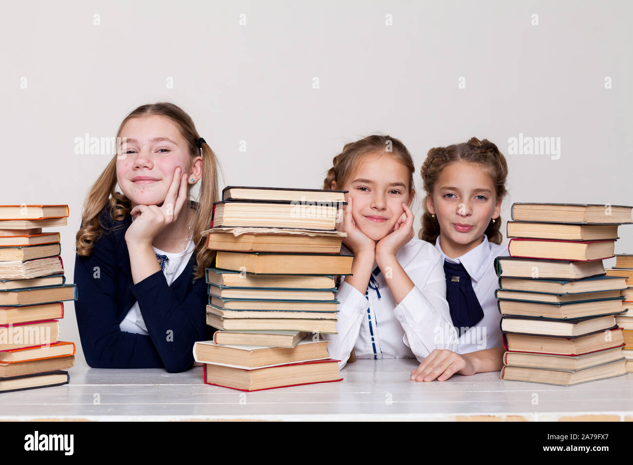 three schoolgirl girls at the desk study books Stock Photo - Alamy