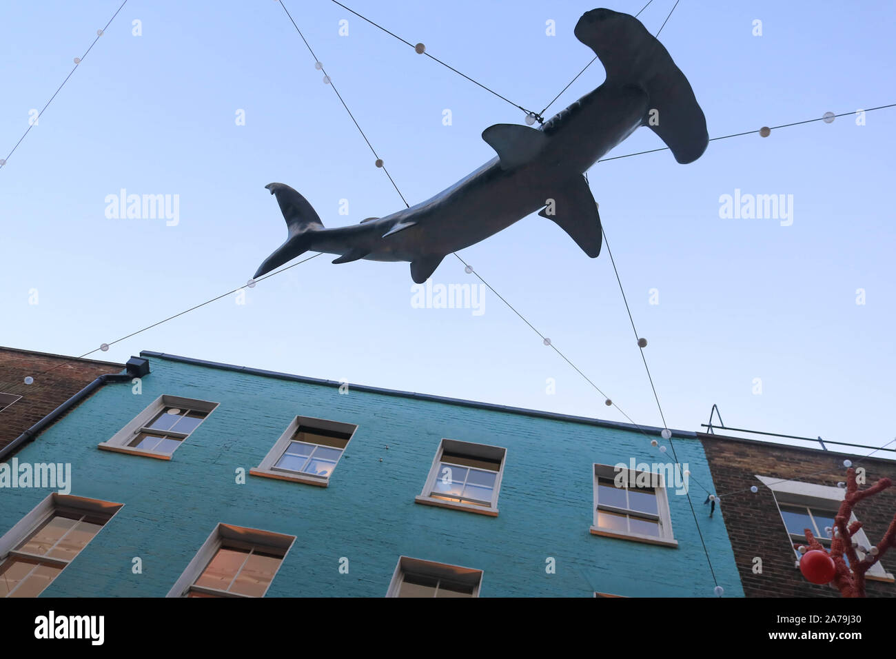 London UK. 31 October 2019. a hammerhead shark suspended above Carnaby ...
