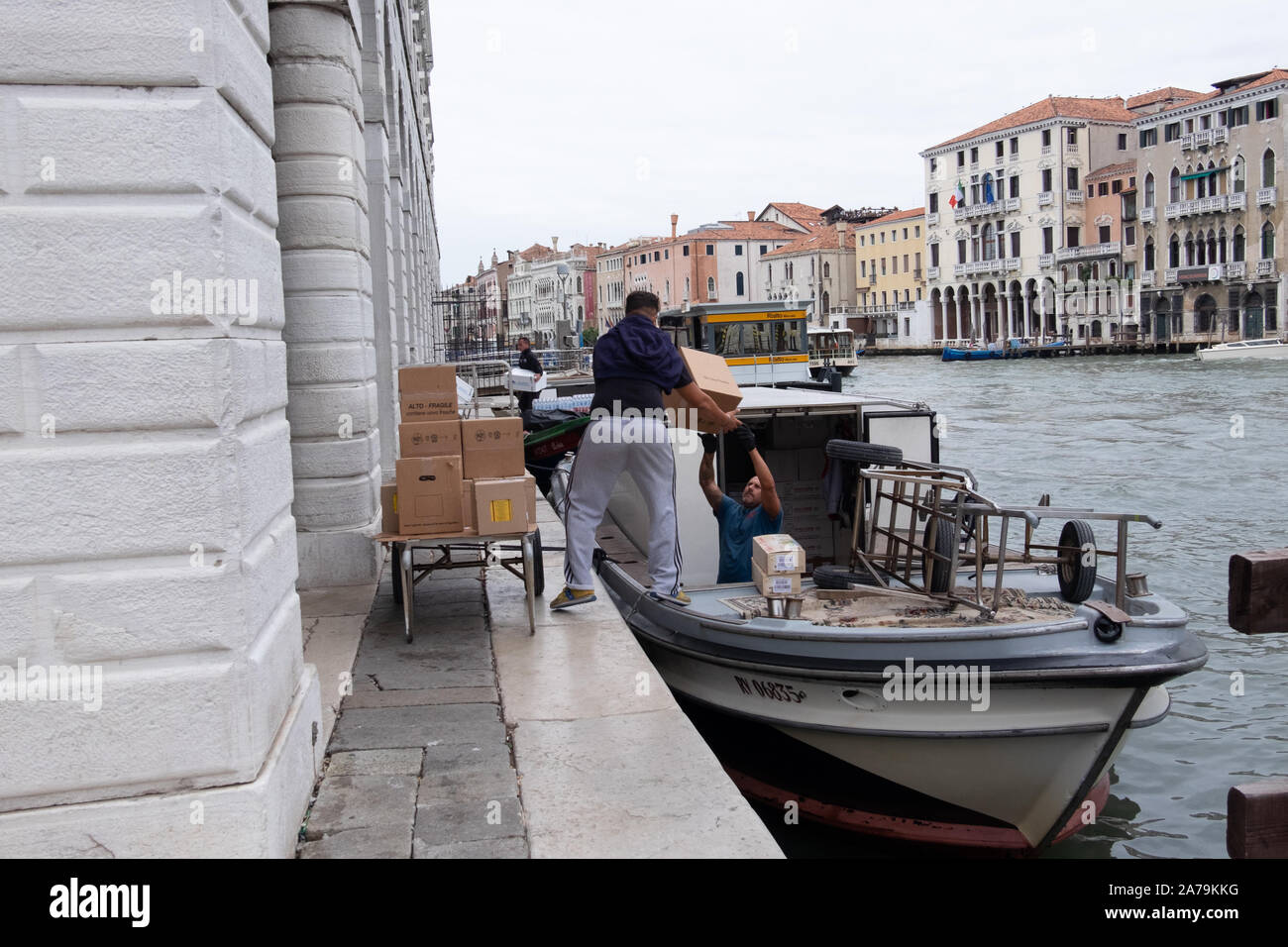 Two men, one on the commercial delivery barge, one on canal side ...