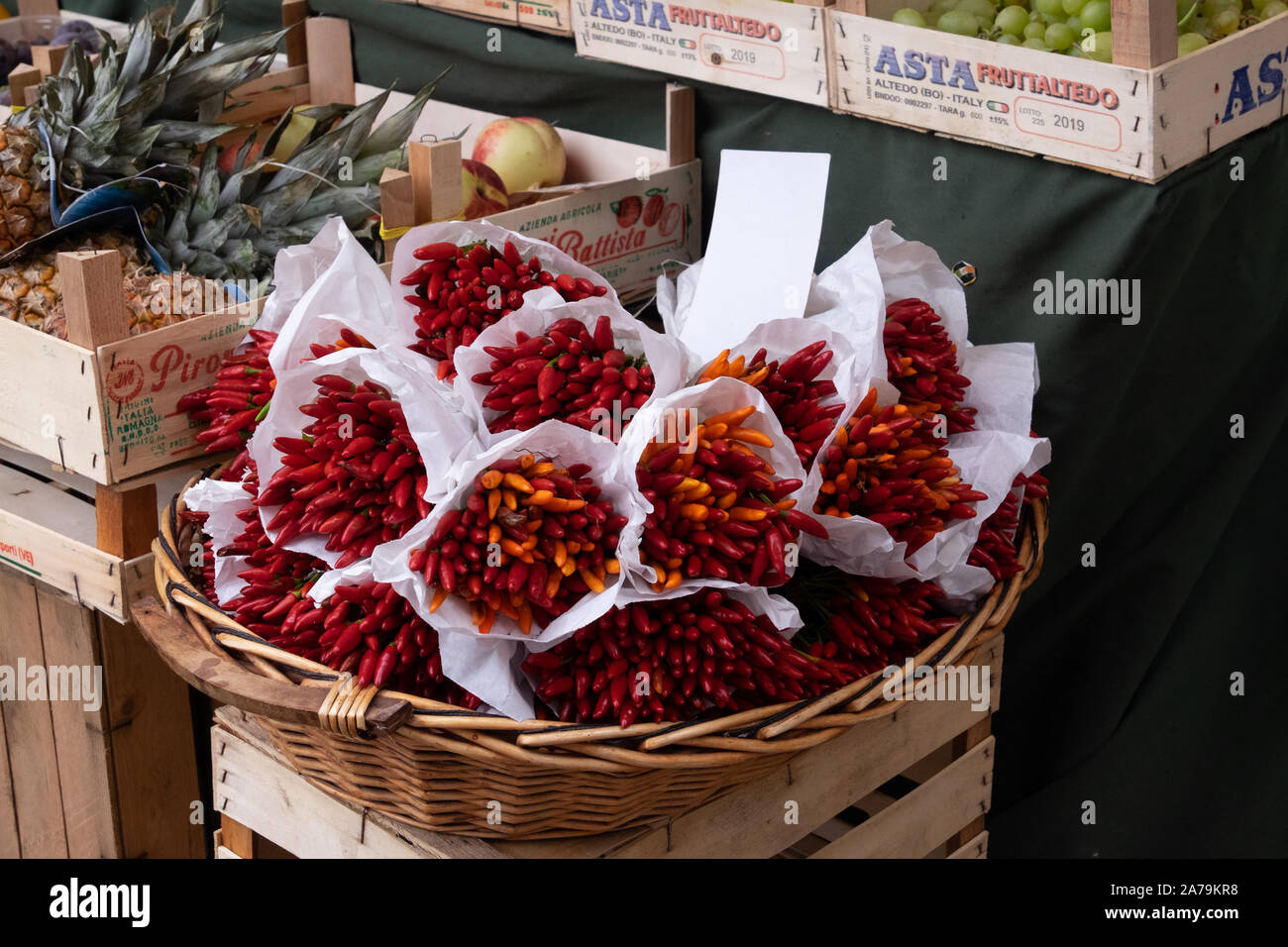 Bright red, hot and spicy, raw chillies displayed in bunches on a ...
