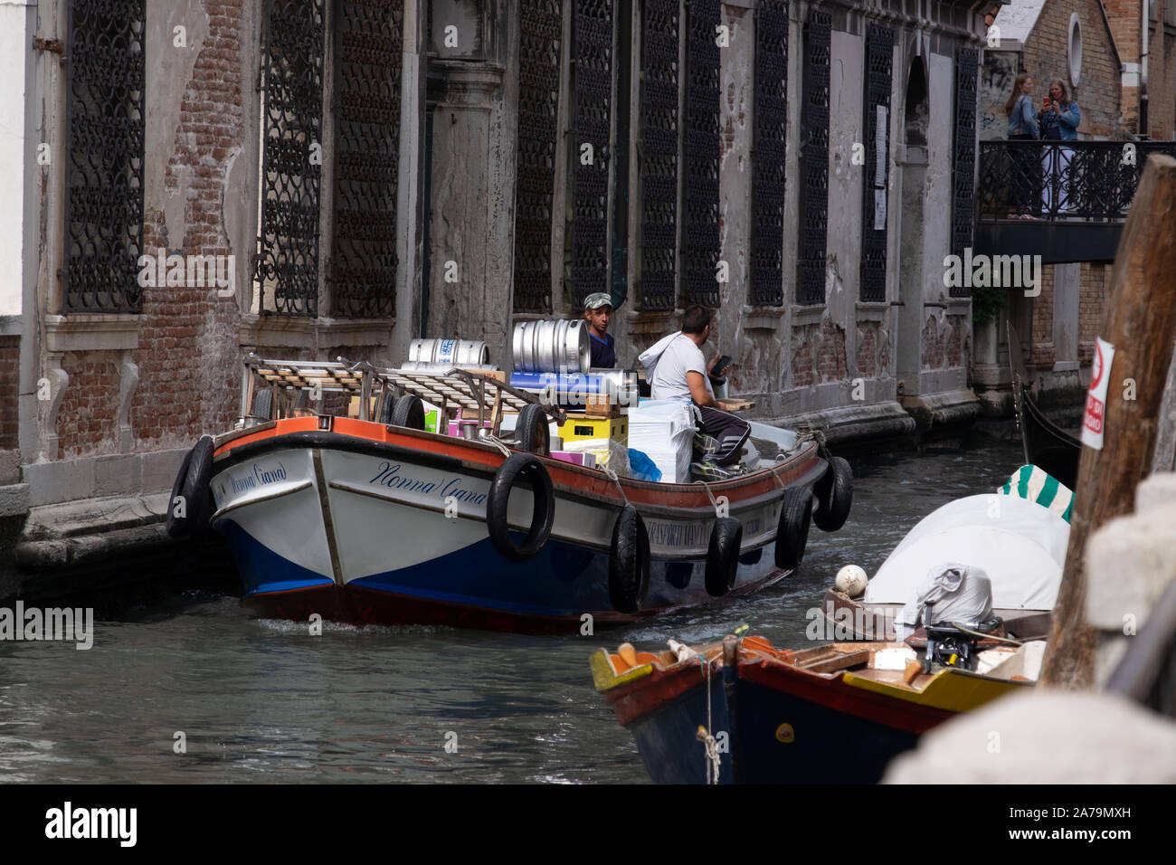 Beer and kegs delivery on a canal barge in the narrow Venetian ...