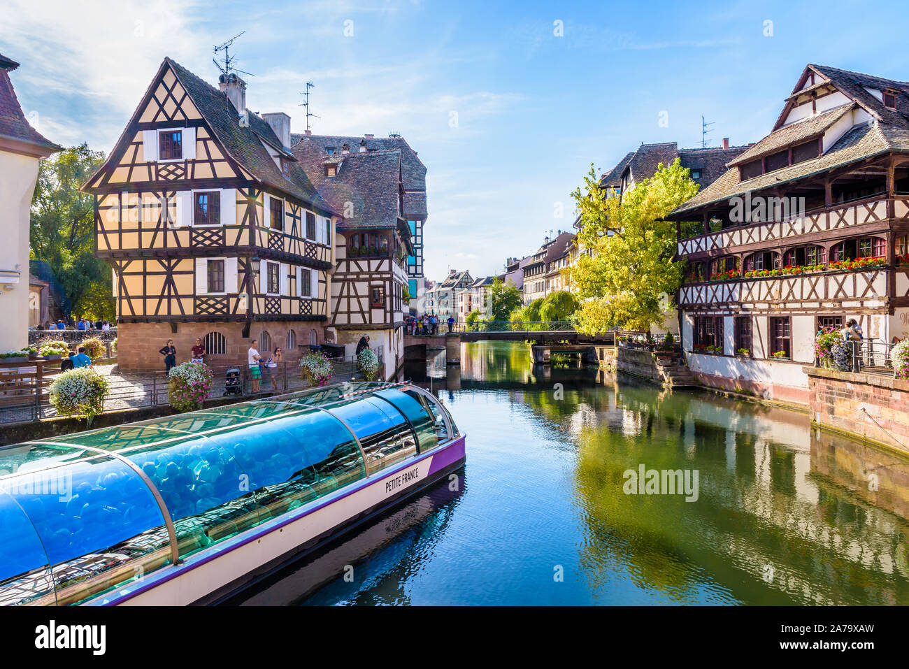 A tour boat is cruising the river Ill canal in the Petite France ...