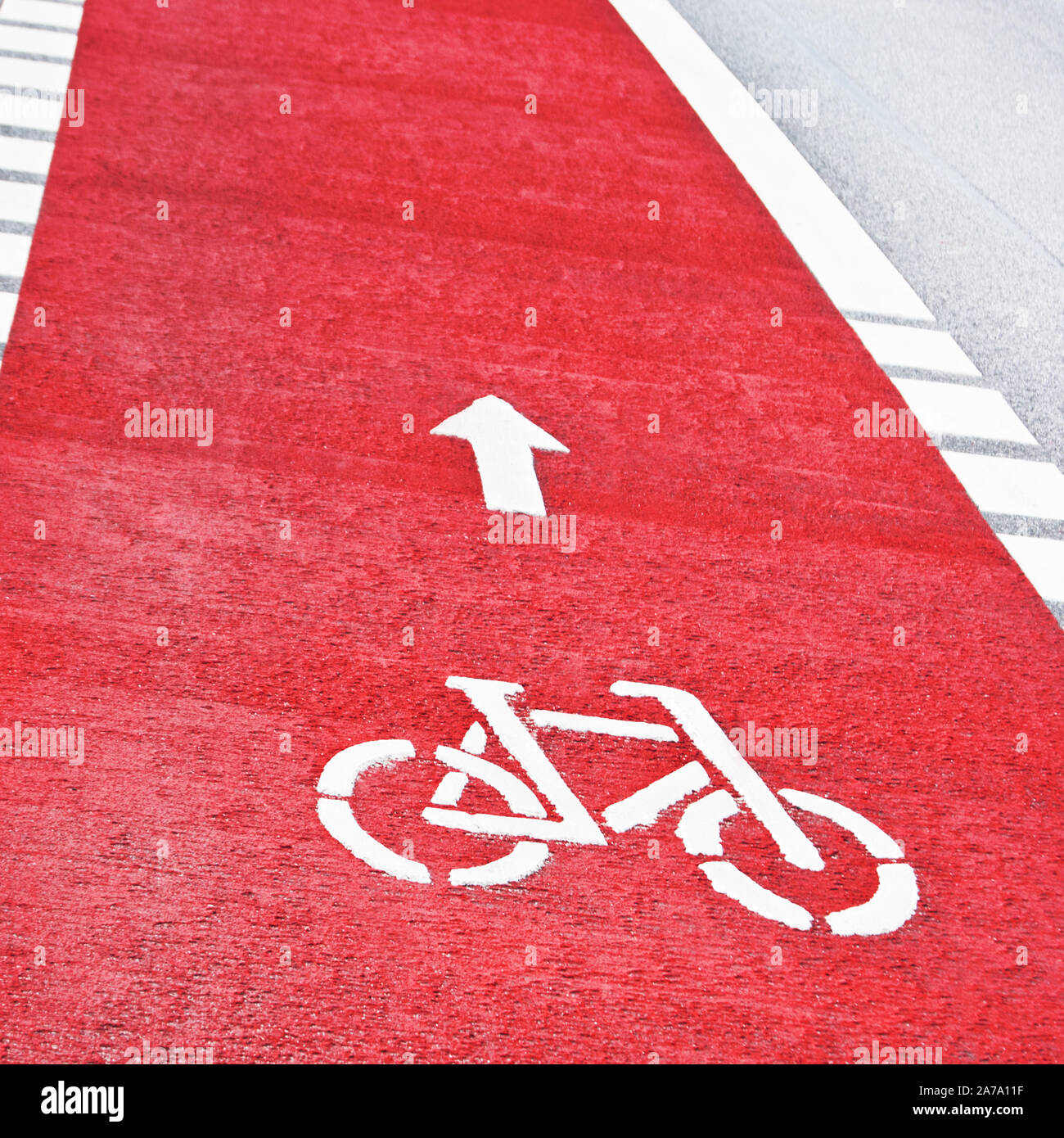Red bicycle path with arrows background Stock Photo - Alamy
