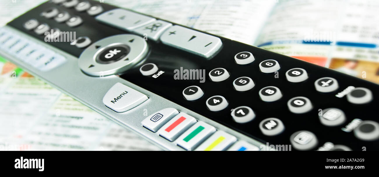 Remote control with tv newspaper as a background Stock Photo - Alamy