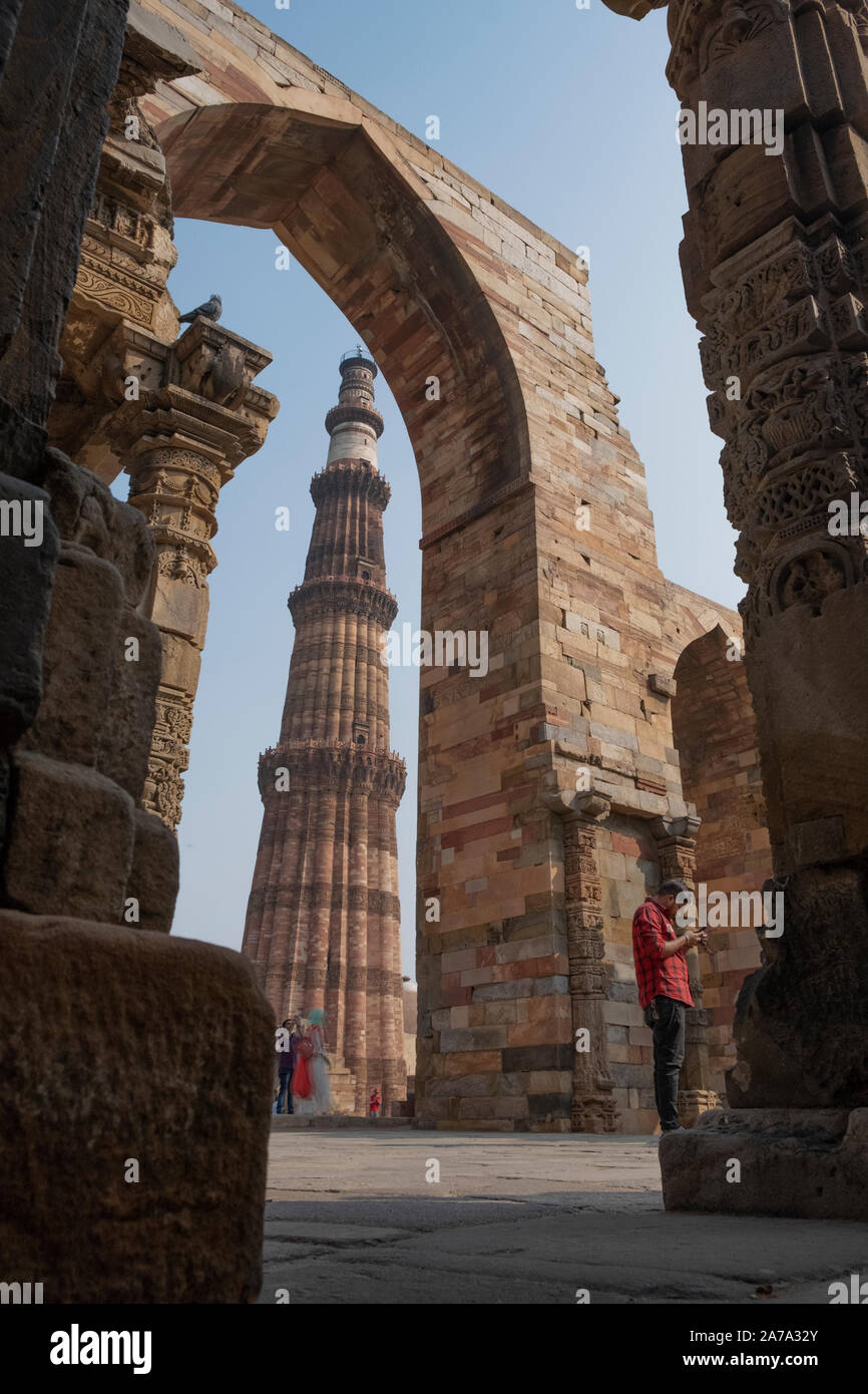 View of Qutub minar against the jain temple pillars and the screen arch ...