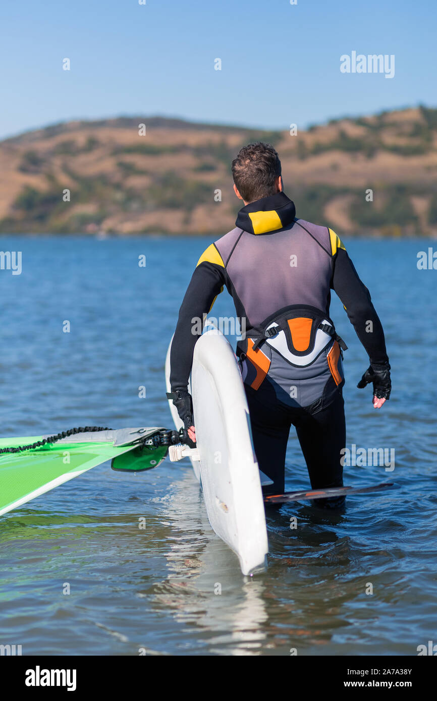 Detail of wind surfer holding board and sail while preparing for the ...