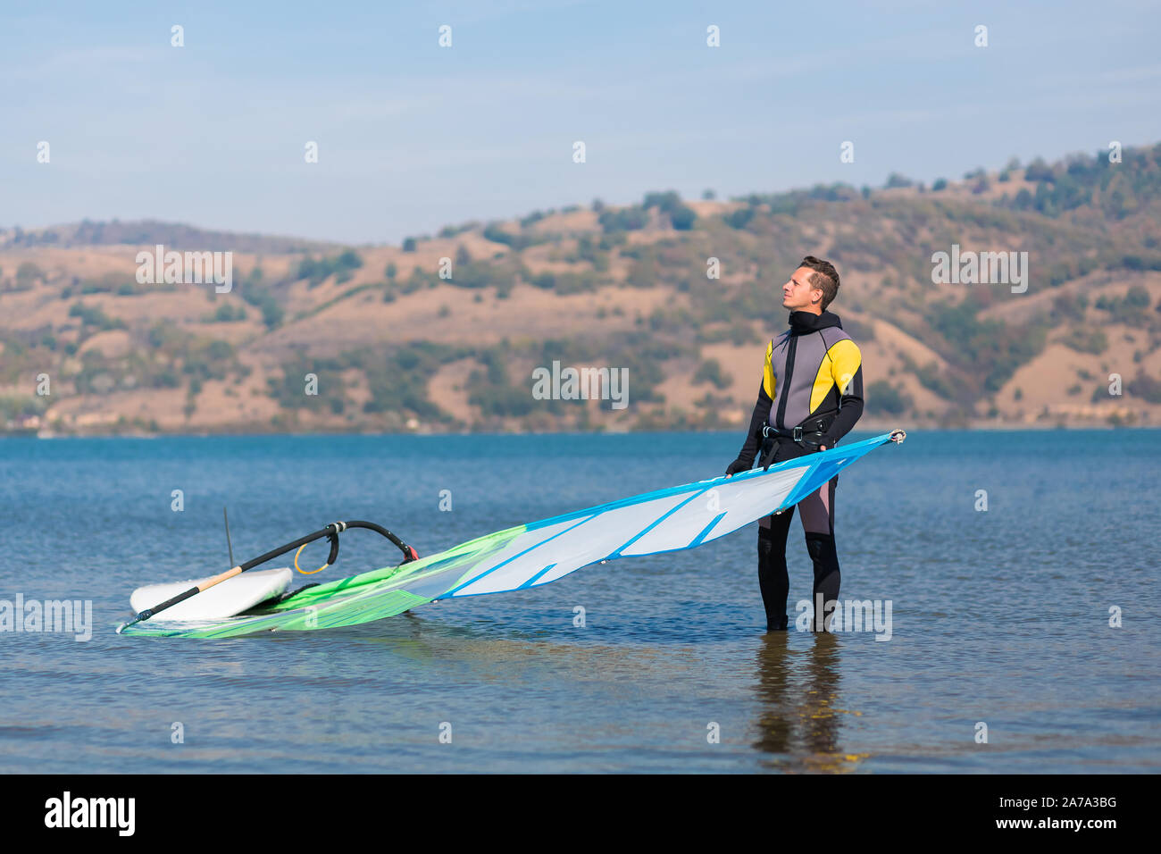 Portrait of windsurfer holding sail in shallow water at the beach Stock ...