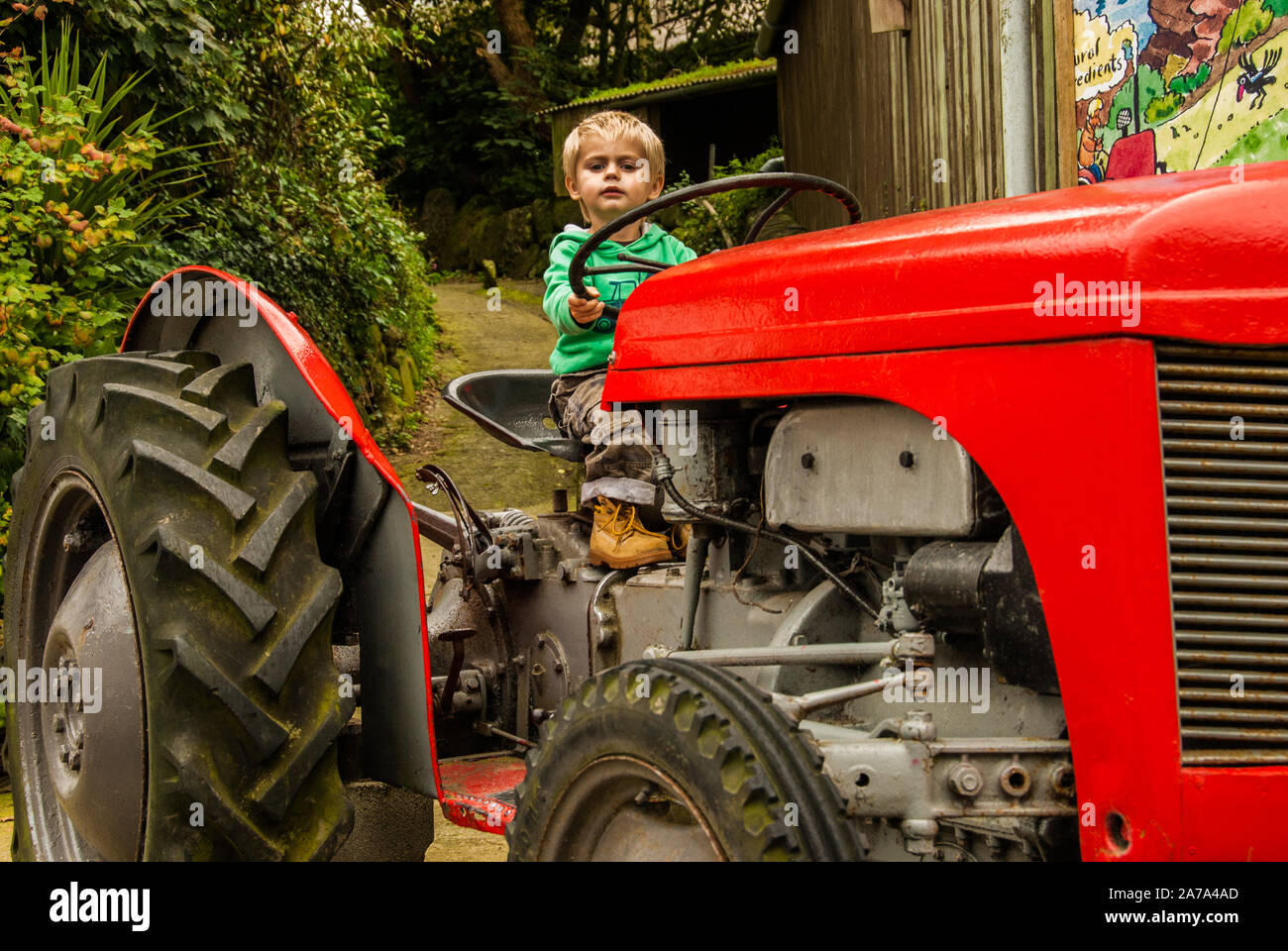 Boy on tractor Stock Photo - Alamy