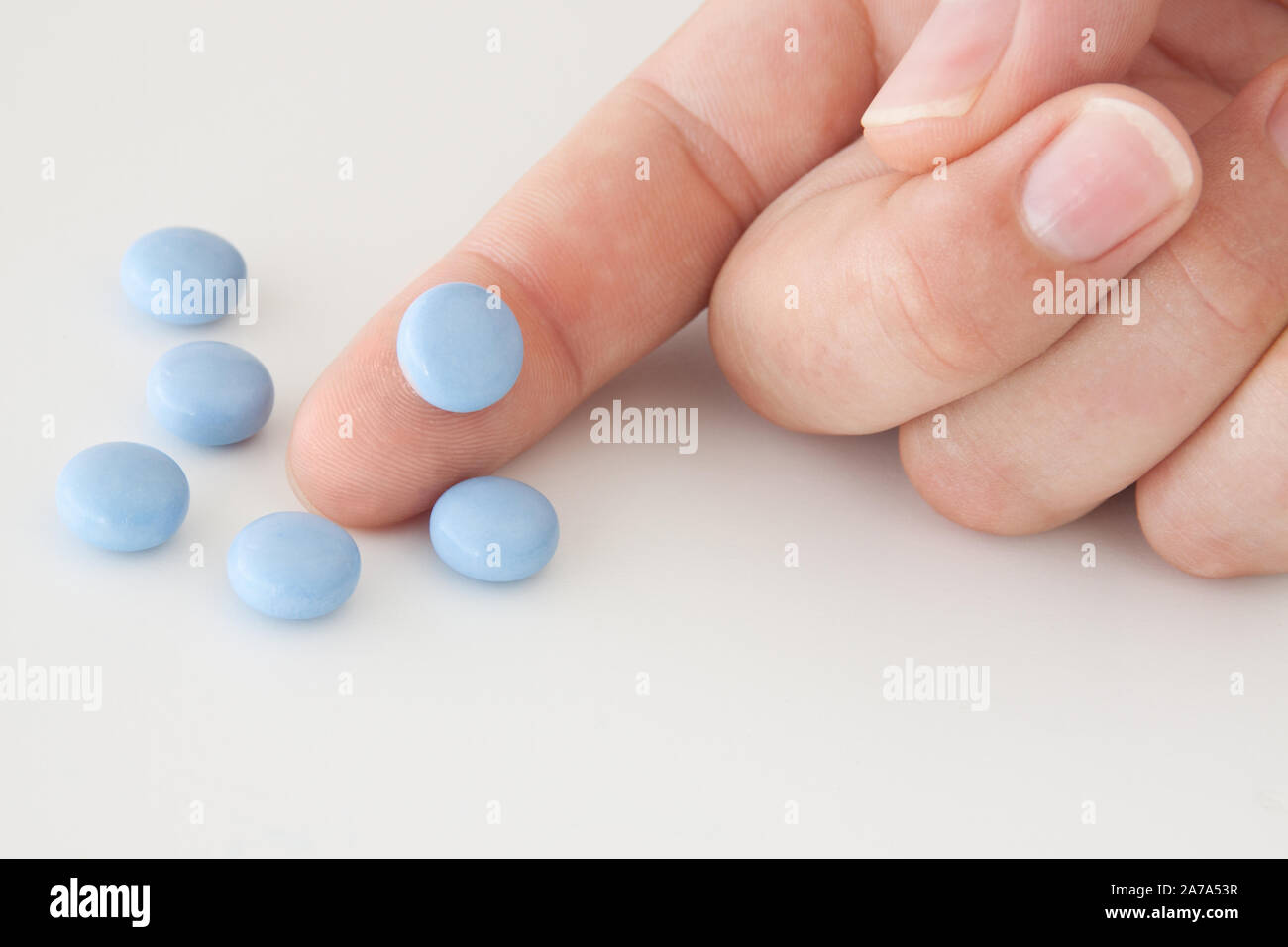 Medicine blue tablets in blister on white background Stock Photo - Alamy