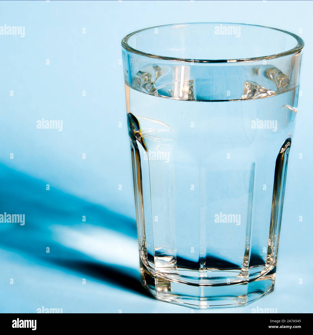 Water glass with strong shadows on white background Stock Photo - Alamy