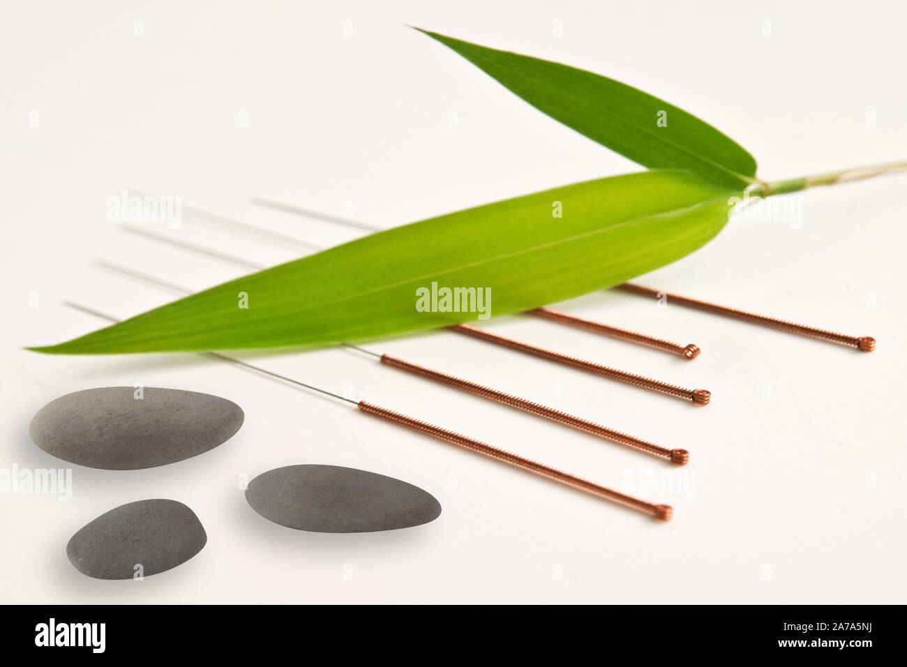 Acupuncture needles with bamboo leaf and stones background Stock Photo ...
