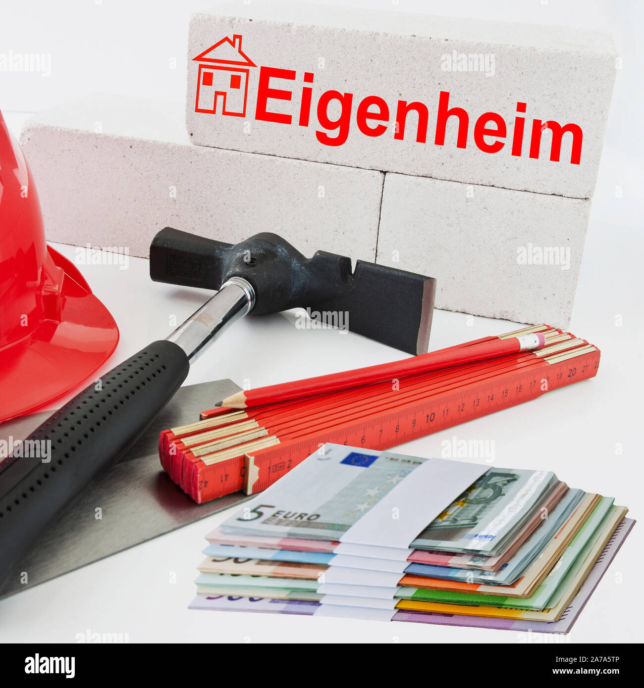 Construction helmet, folding rule, hammer and bricks on white ...