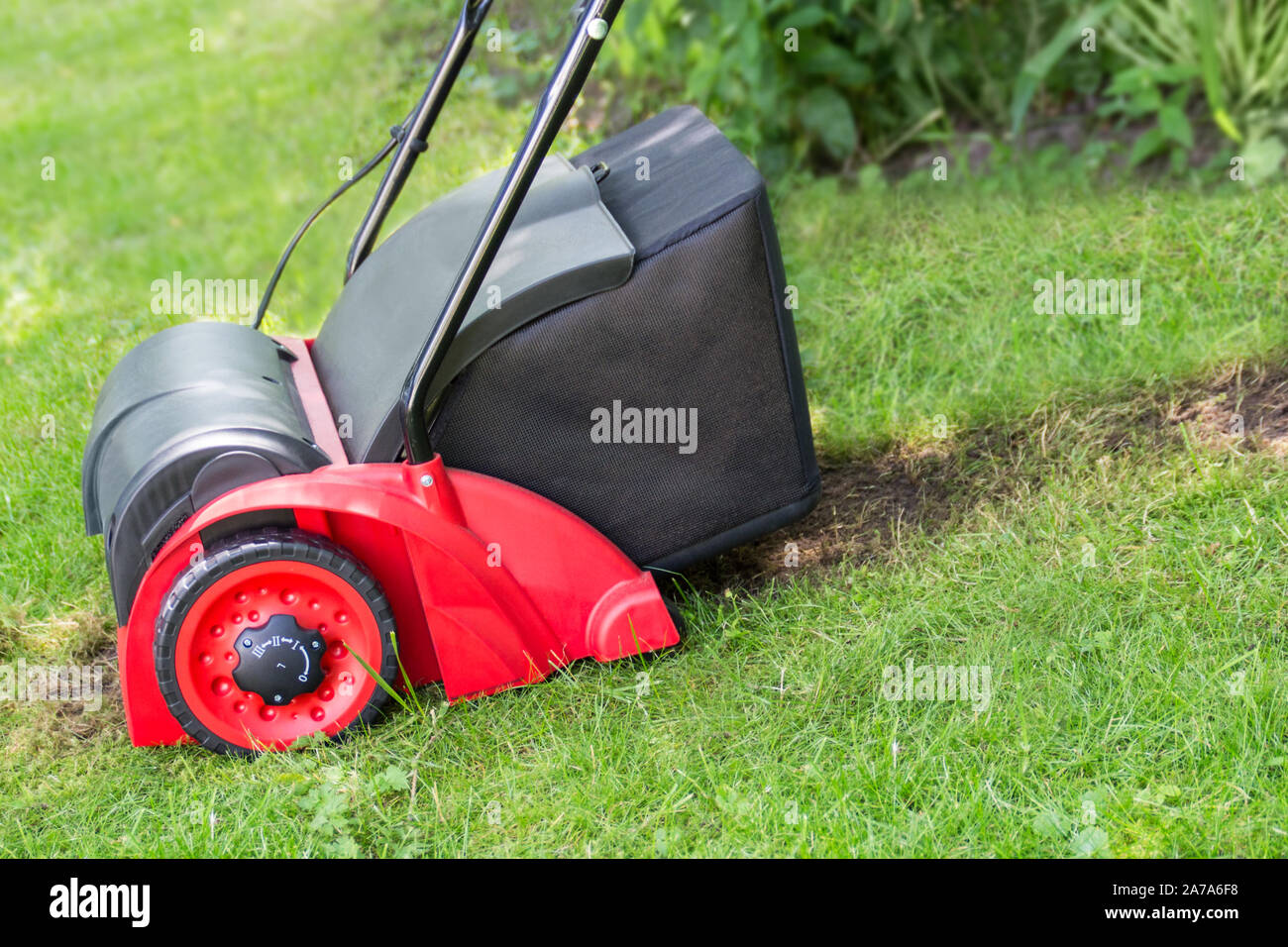 Lawn care scarifier on grass as background Stock Photo - Alamy