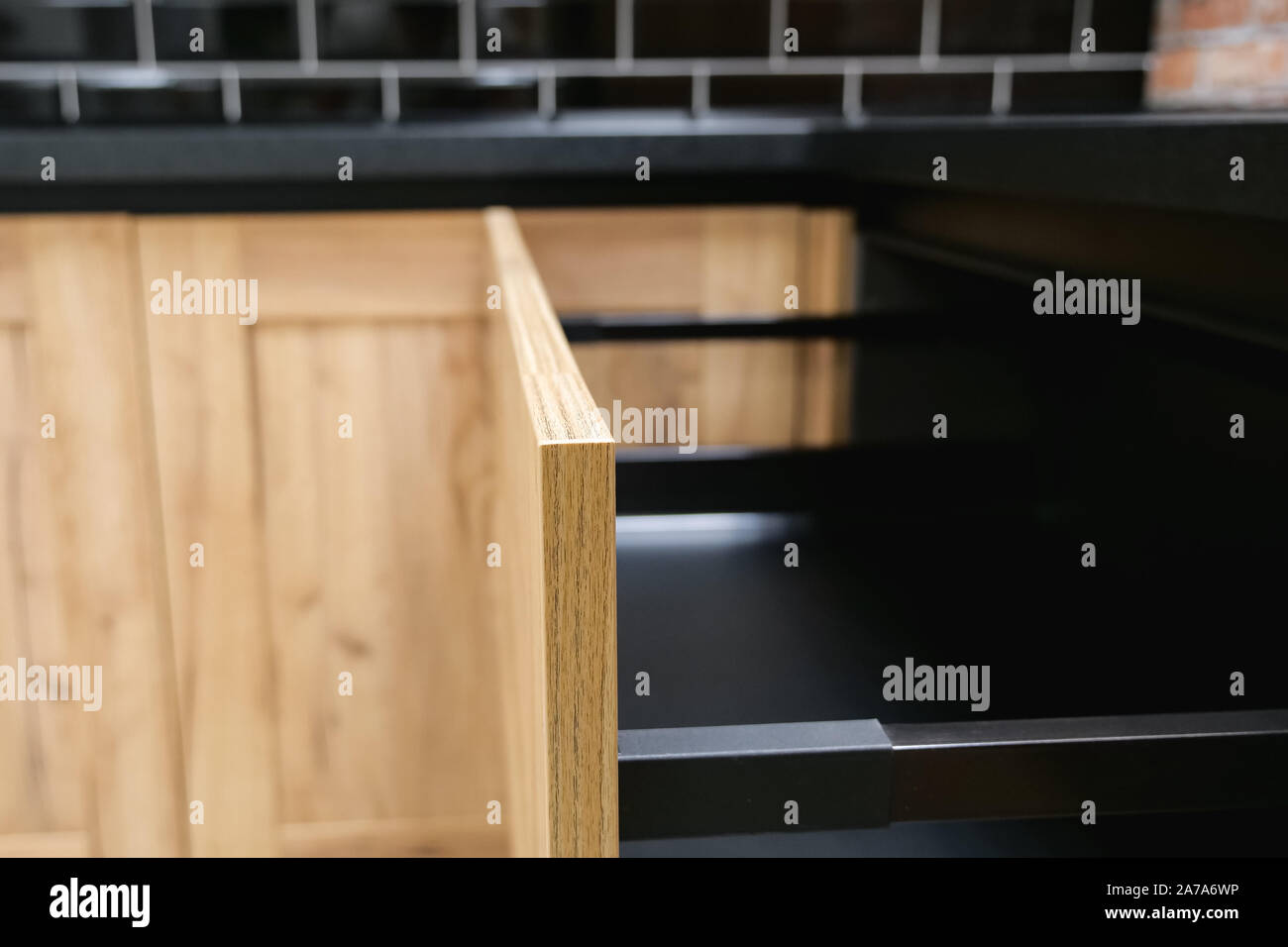 empty drawer made of black metal and wooden front panel in modern ...