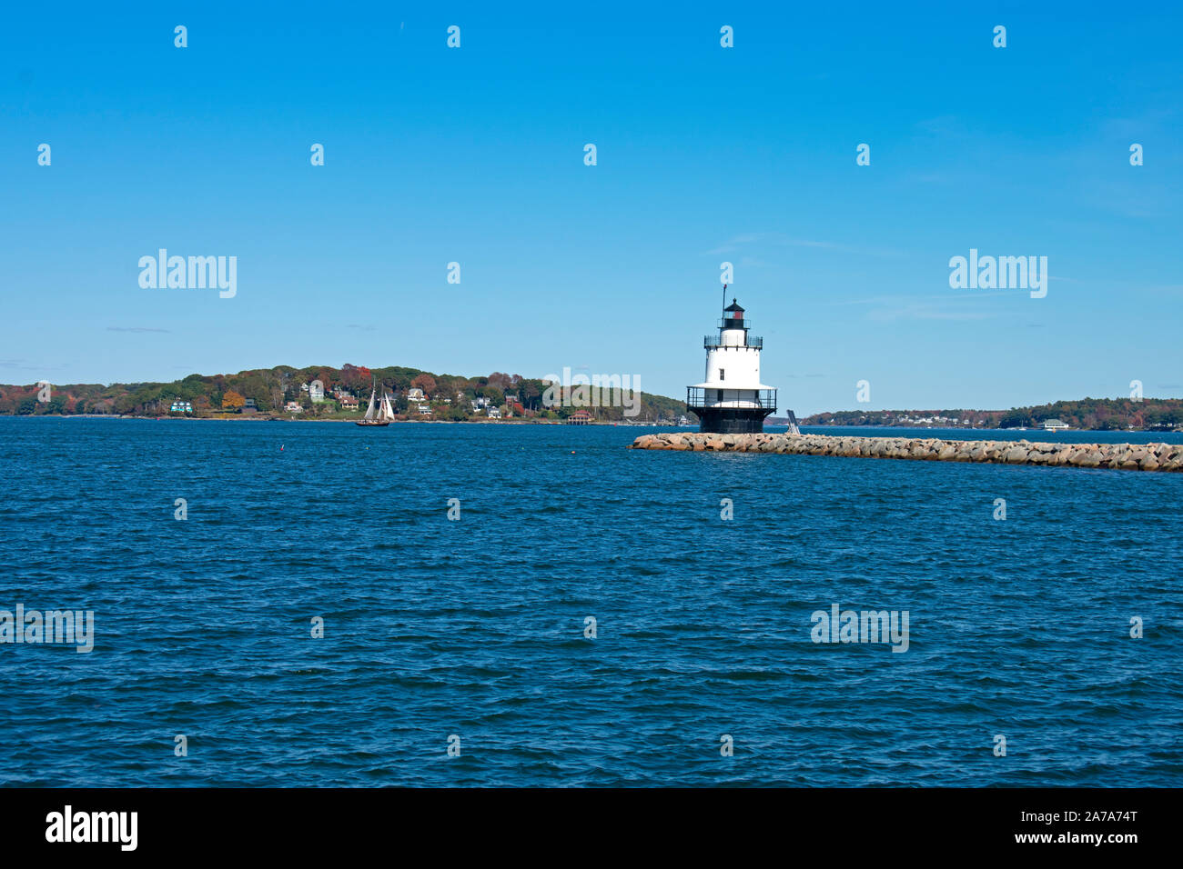 Sparkplug type black and white lighthouse situated on a long rocky ...