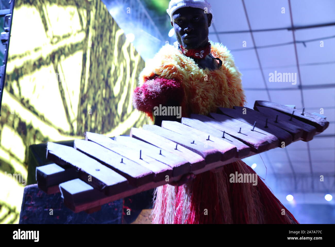 African man carrying a traditional Xylophone out of the stage after his ...