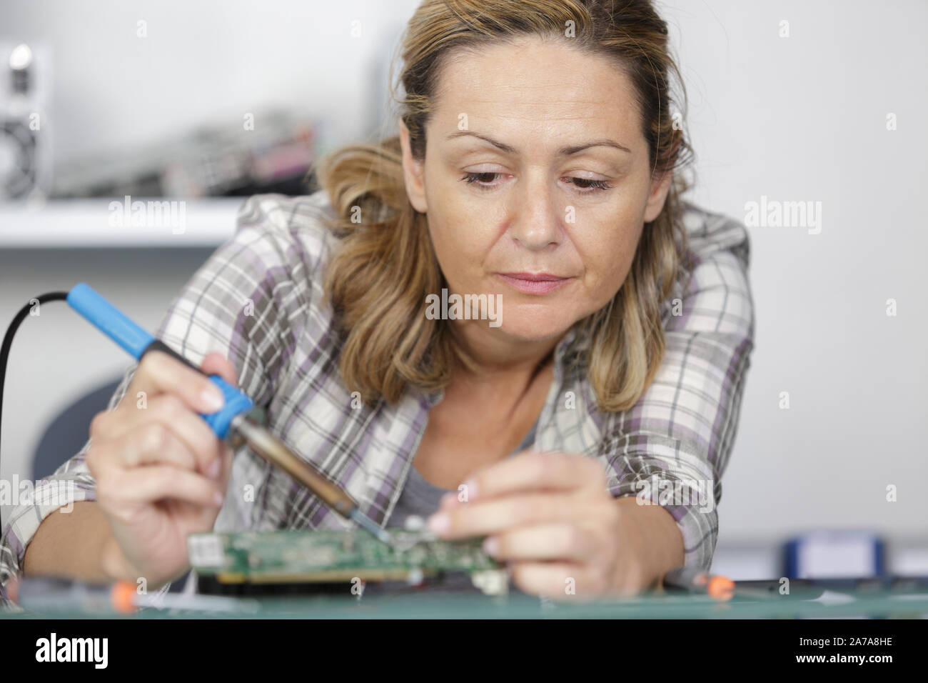 woman soldering elements of circuit board Stock Photo - Alamy