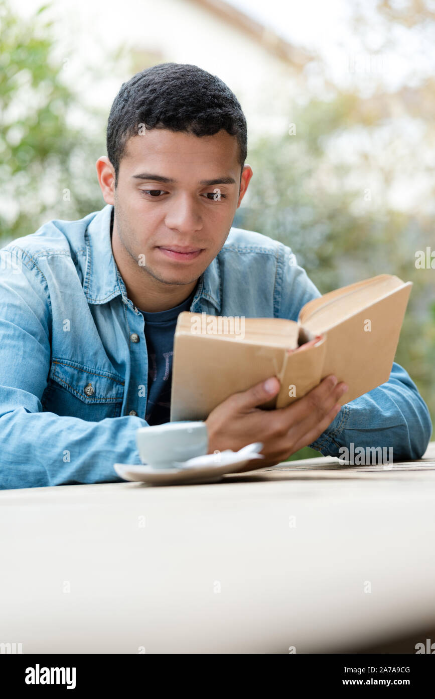 relaxation man reading a book outdoors Stock Photo - Alamy