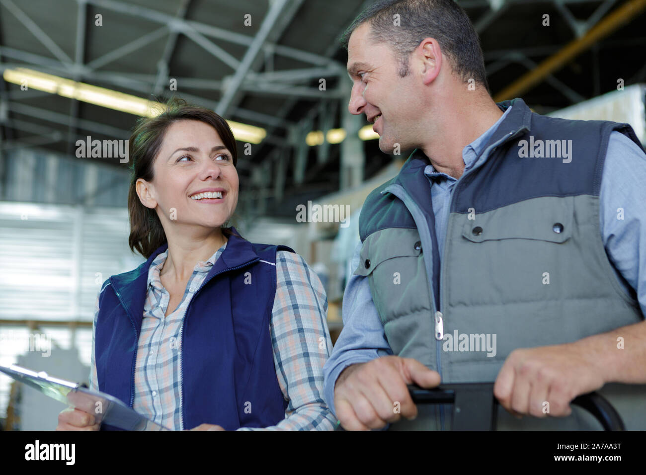 friendly warehouse workers smiling at each other Stock Photo - Alamy