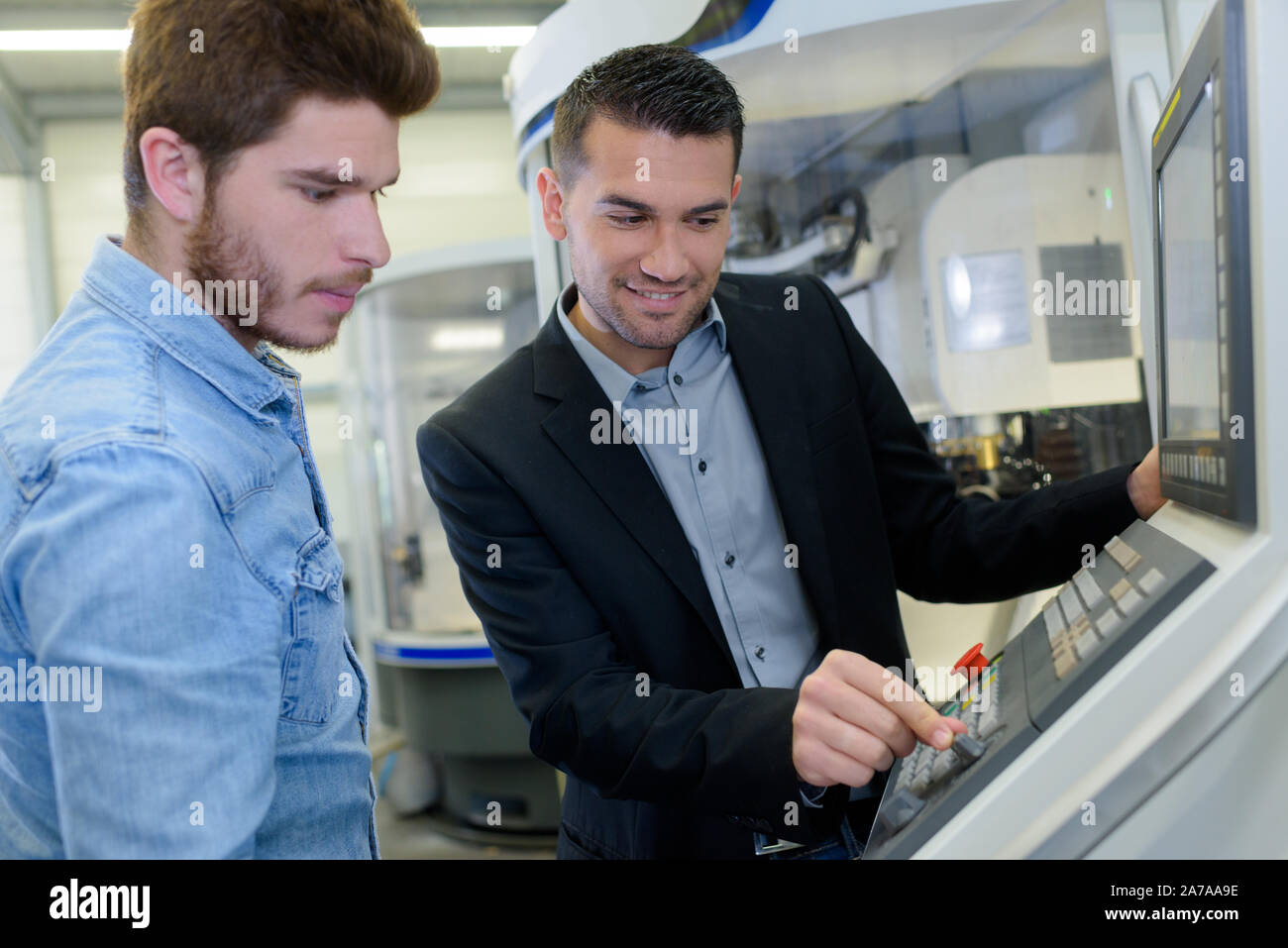 male apprentice learning to use a machine Stock Photo - Alamy
