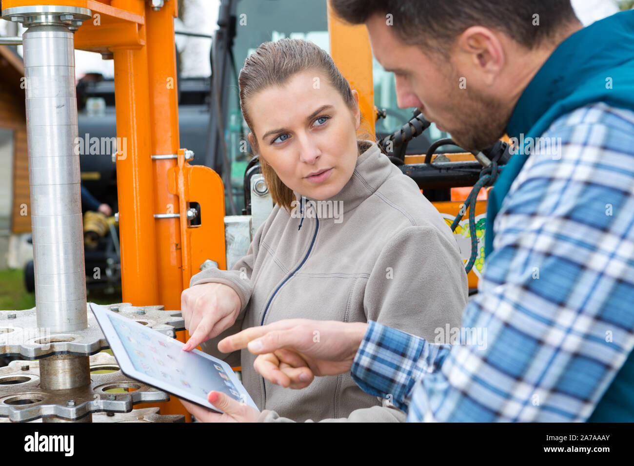 female factory worker and colleague using digital tablet Stock Photo ...