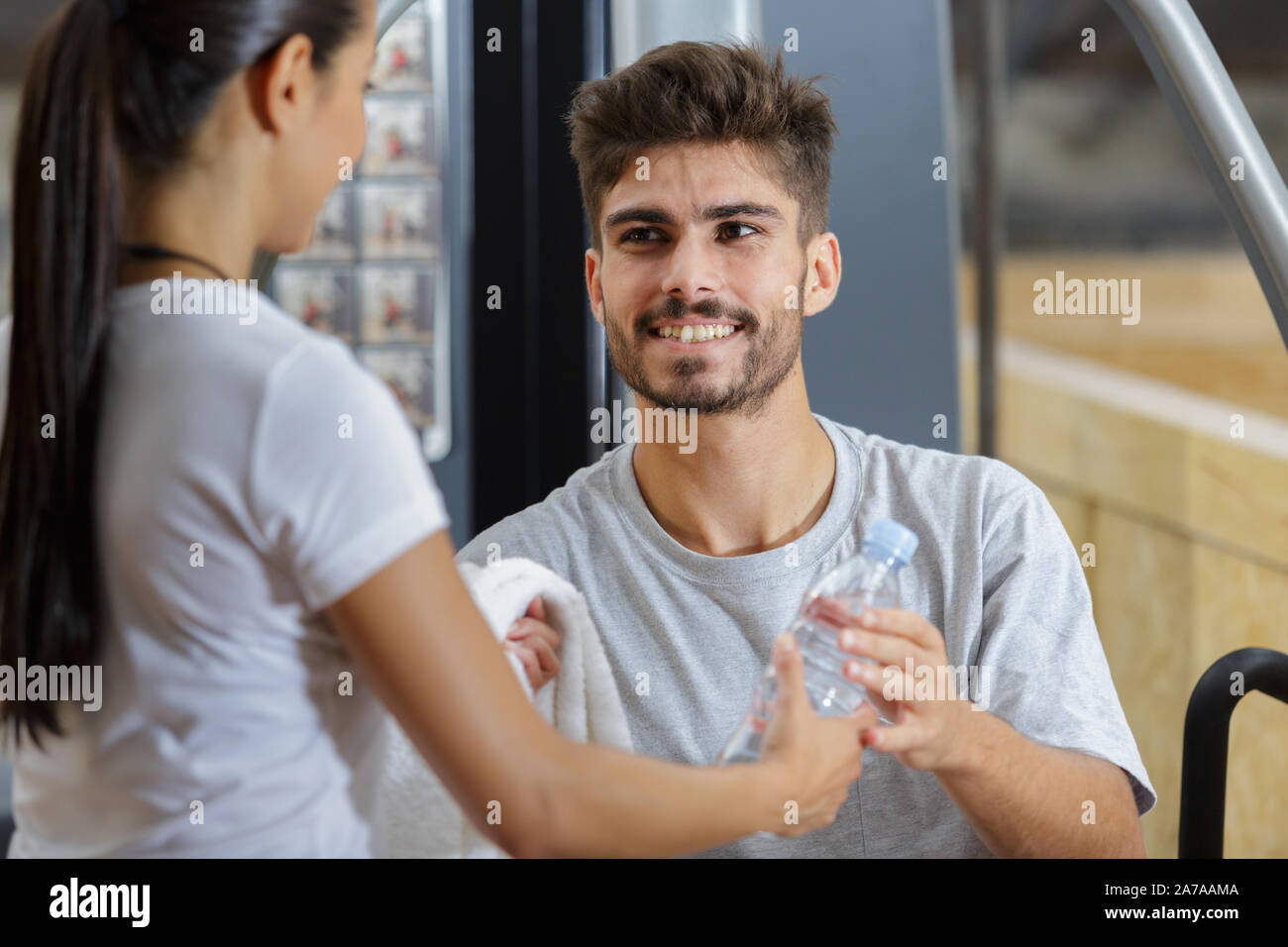 personal trainer passing water to sportsman Stock Photo - Alamy