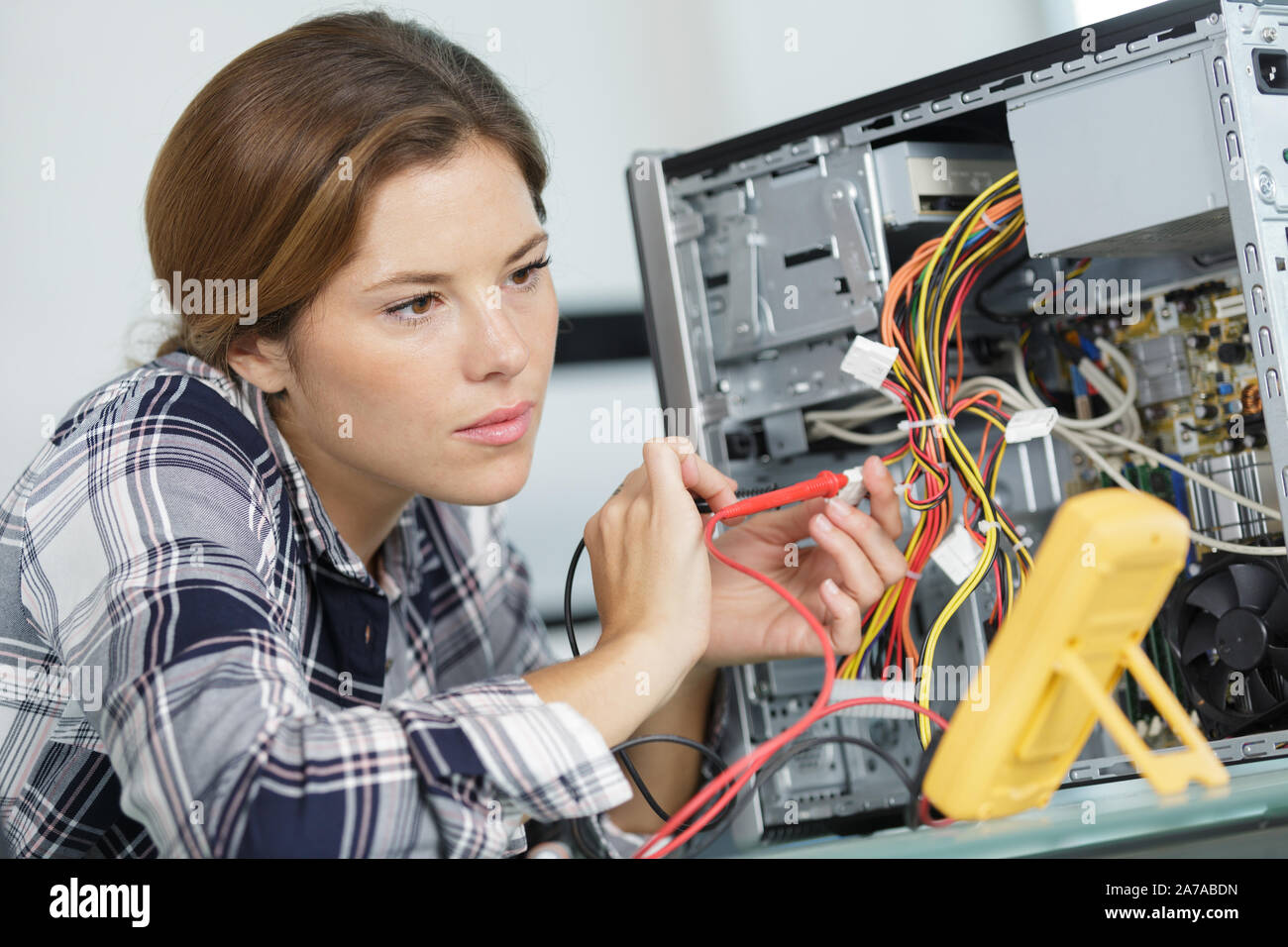 woman checking computer with a multimeter Stock Photo - Alamy