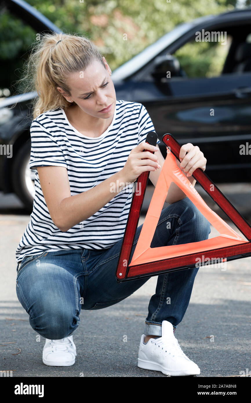 young female driver making a safety triangle Stock Photo - Alamy