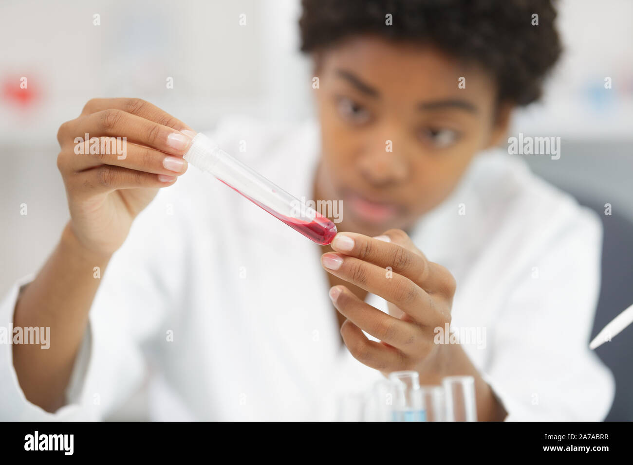 female lab worker looking at blood sample Stock Photo - Alamy
