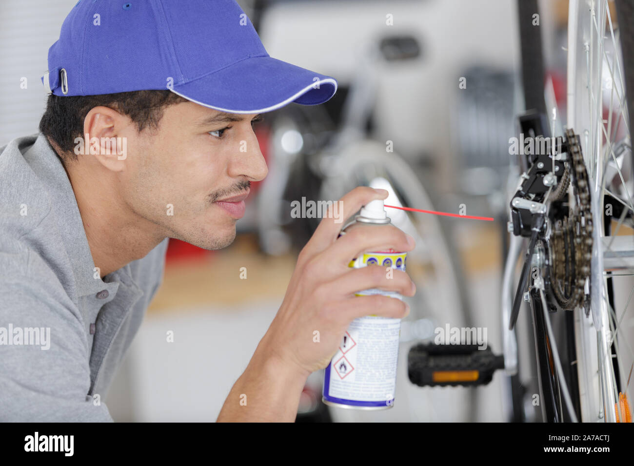 man oiling a bicycle chain and gear with oil spray Stock Photo - Alamy