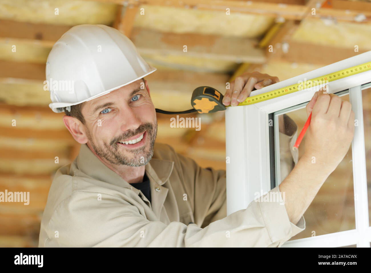 man measuring window prior to installation Stock Photo - Alamy