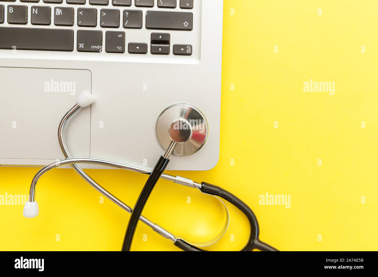 Stethoscope keyboard laptop computer isolated on yellow background ...