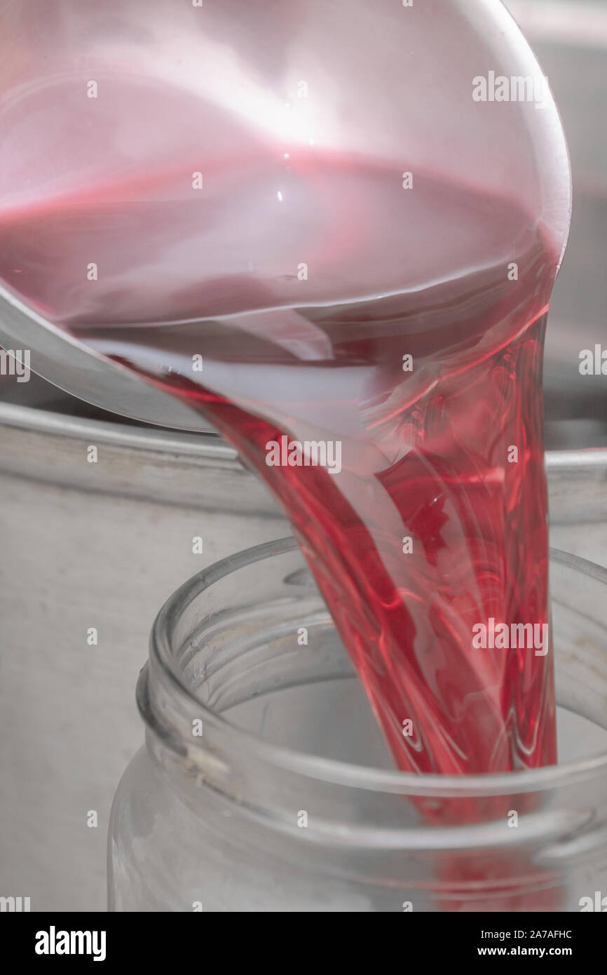 Pouring hot syrup from a ladle into a glass jar Stock Photo - Alamy